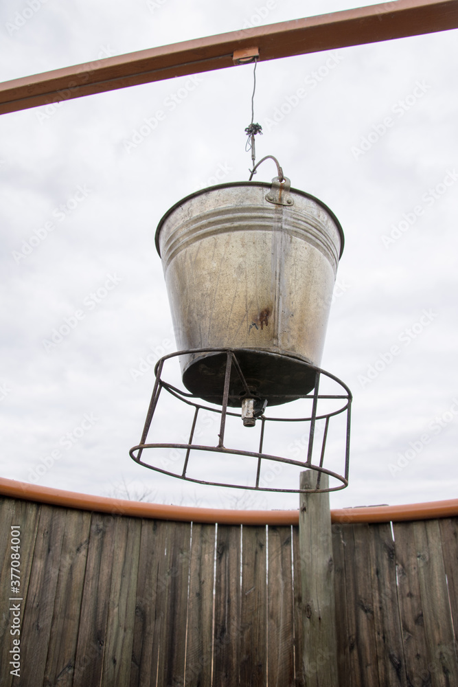 Camp shower in a remote campsite in Africa. A bucket with a small tap ...