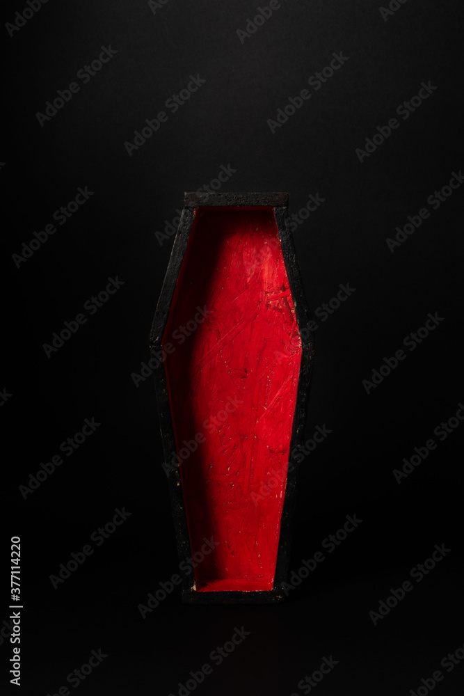 Miniature open black-red coffin on a black background. Festive ...