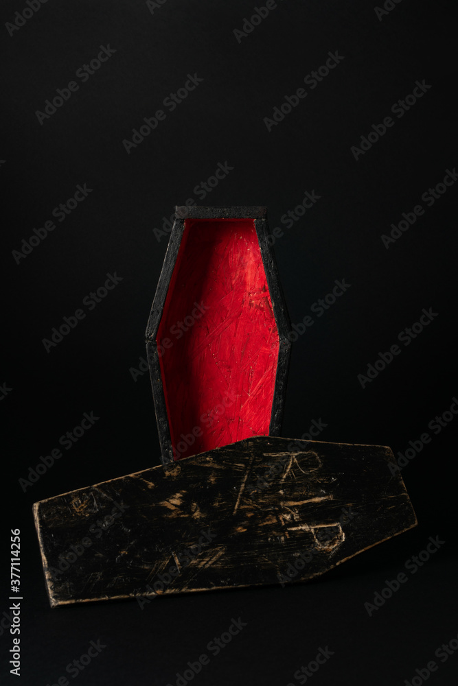 Miniature open black-red coffin on a black background. Festive ...