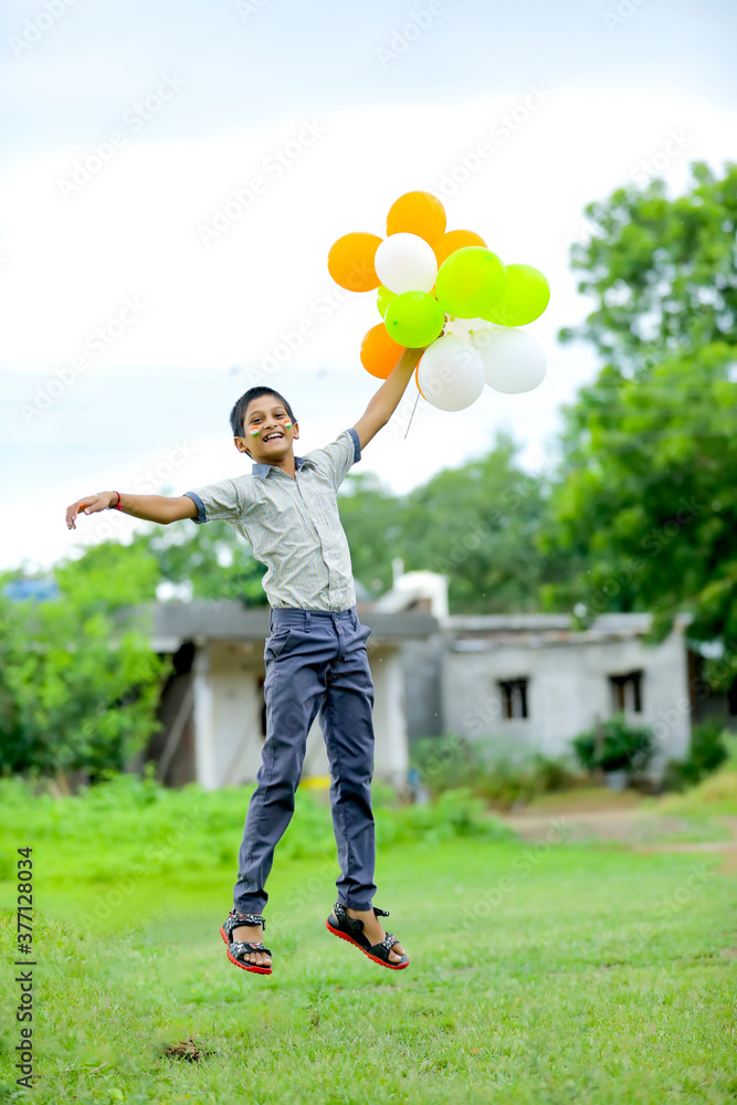 little indian school boy Jumping in sky with tri color balloons and ...