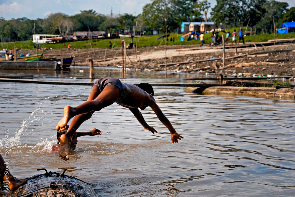 crianças nadando e brincando no rio solimões nas proximidades do porto ...