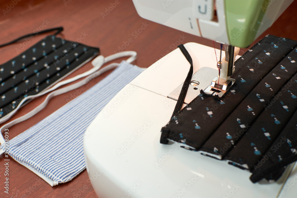 Sewing machine prepared to make face masks, on one side finished face ...
