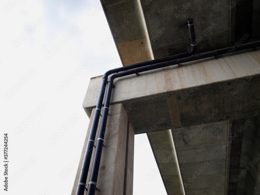 Foto de Drain pipes under a highway bridge. Black plastic pipes are ...
