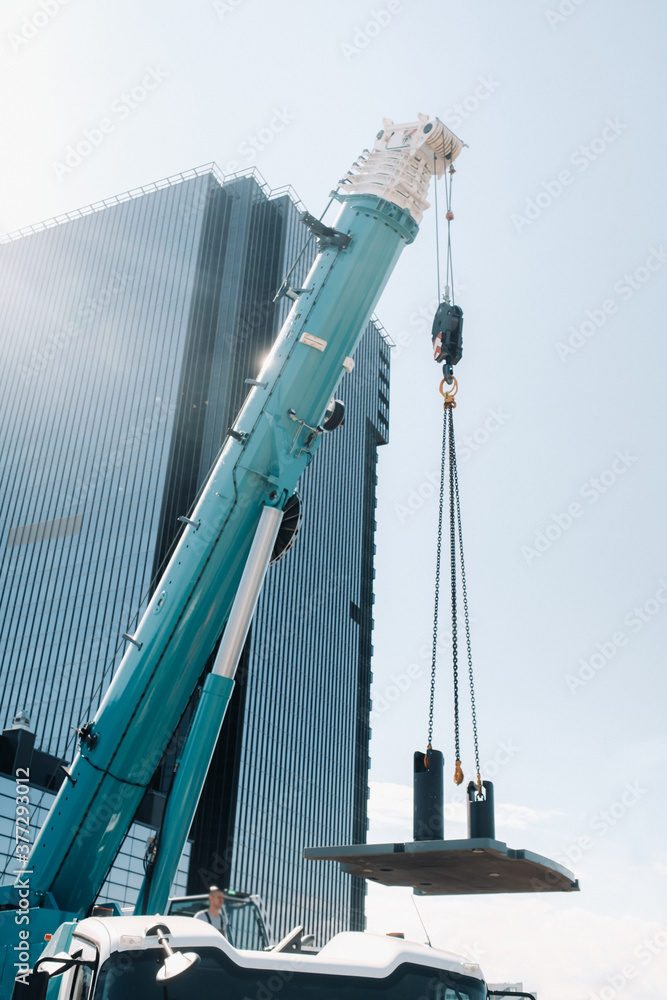 the stove is loaded onto a large blue car crane and prepared for ...