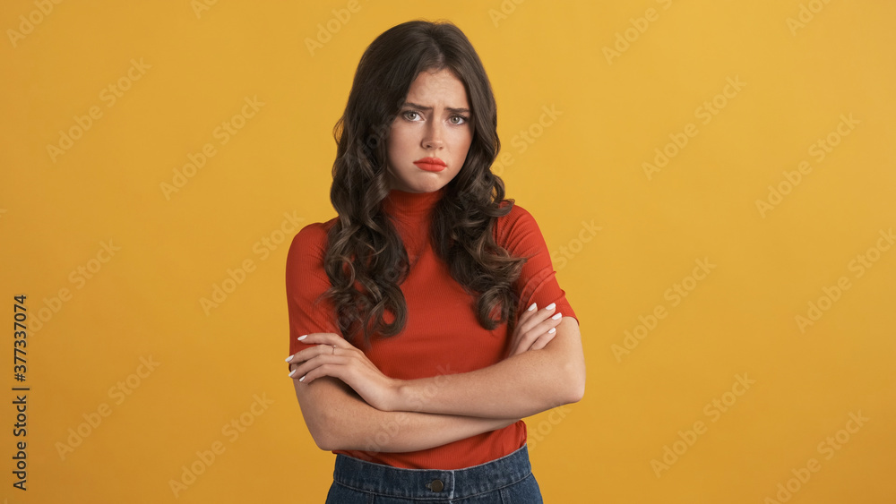 Offended upset girl in red top with hands crossed sadly looking in ...
