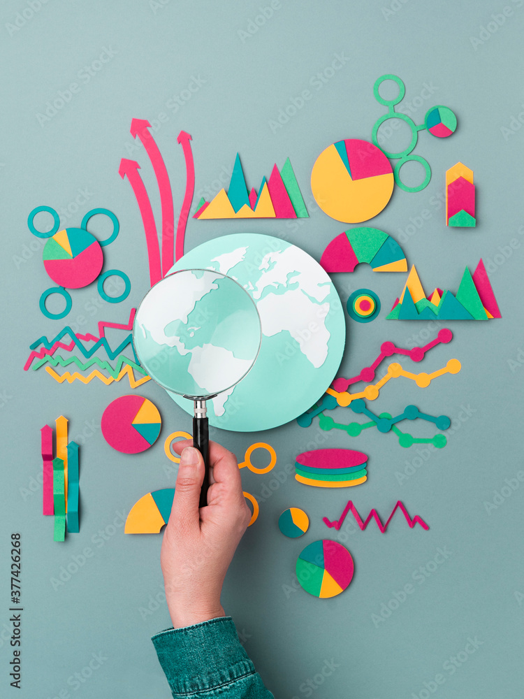 Statistics. Hand with a magnifying glass looking in a world map ...