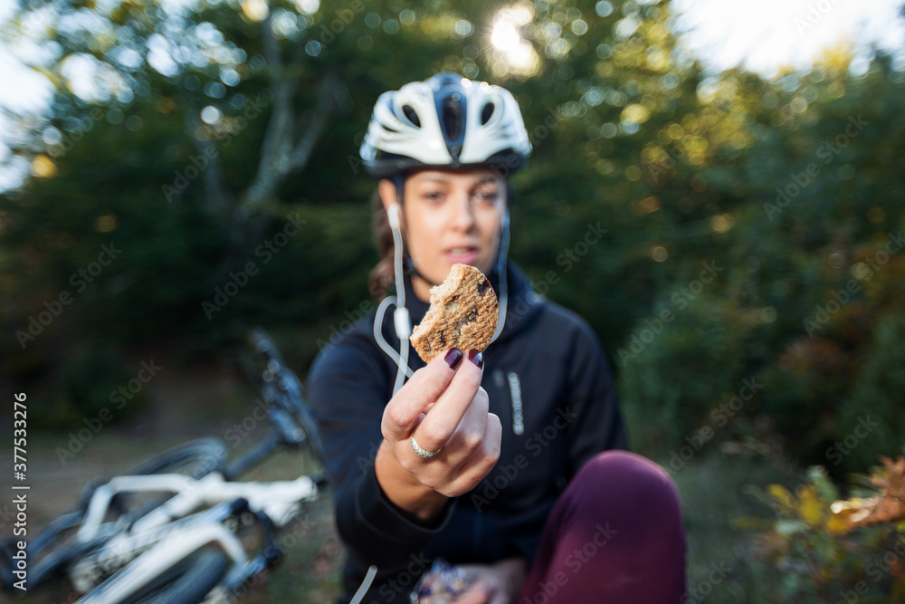 Young female cyclist eating integral biscuits Stock Photo | Adobe Stock