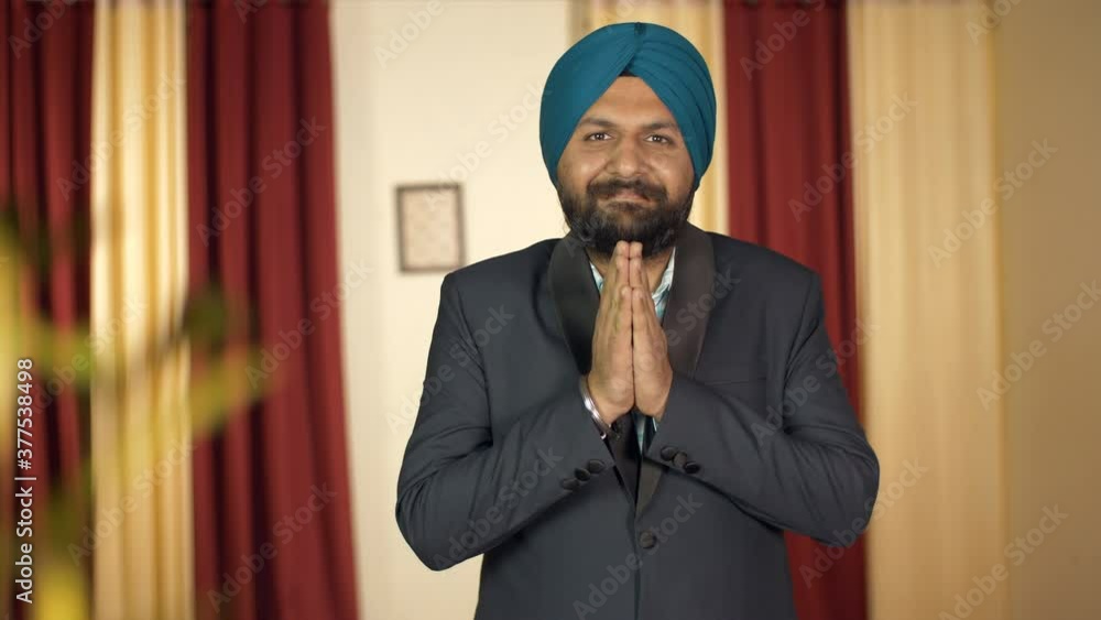Portrait shot of an Indian businessman joining his hands with a smile ...