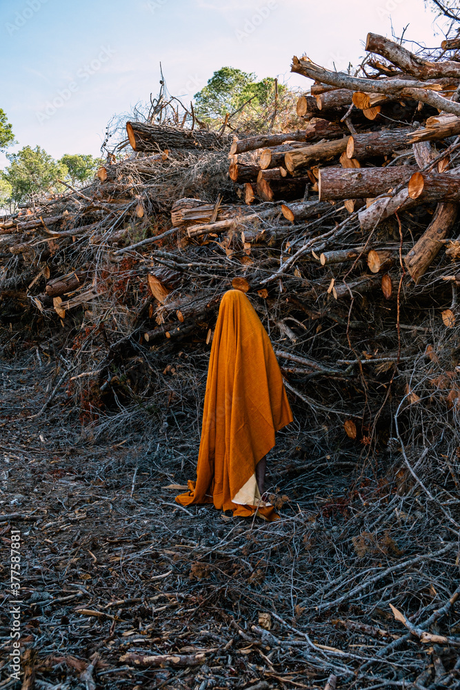 Person wearing a ghost costume made from orange sheet and standing ...
