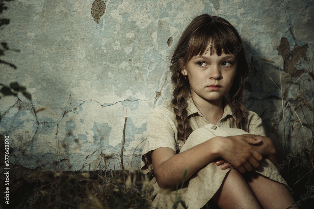 sad teenage girl sitting by an abandoned building Stock Photo | Adobe Stock