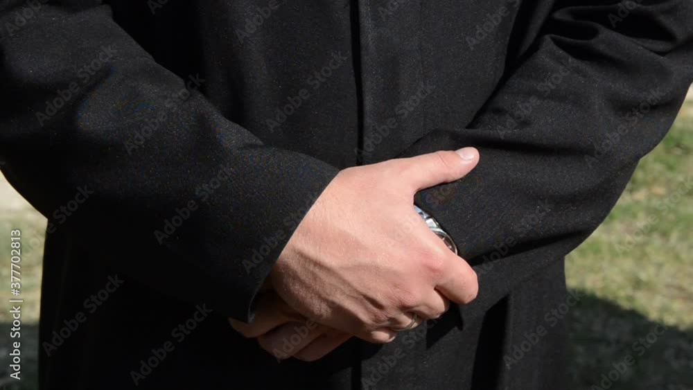 Clasped hand position. Priest cross his arms during praying in mosque ...