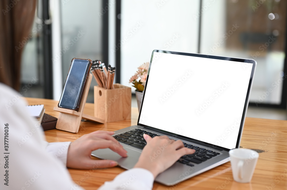Cropped shot woman typing mockup laptop computer with blank screen ...
