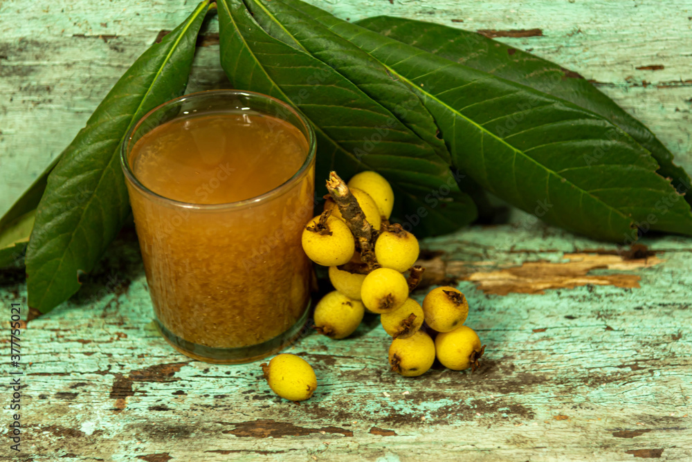 Glass of loquat fruit juice (Eriobotrya japonica) on aged wooden ...