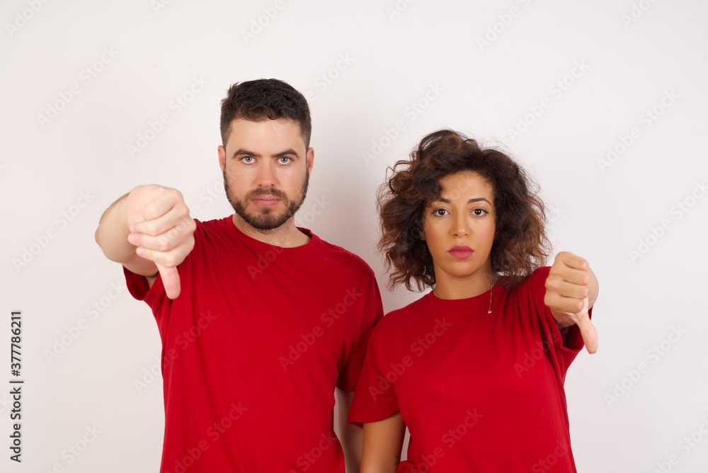 Young beautiful couple wearing red t-shirt on white background being ...