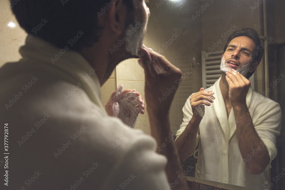 Handsome young man shaving and having his daily routine Stock Photo ...