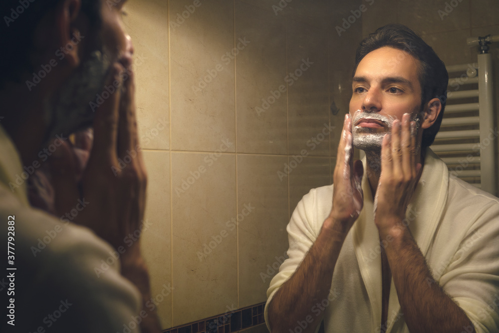 Handsome young man shaving and having his daily routine Stock Photo ...