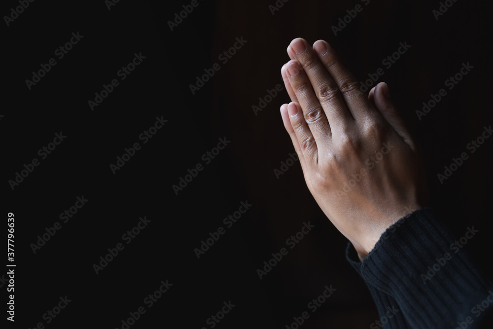 Praying hands with faith in religion and belief in God on dark ...