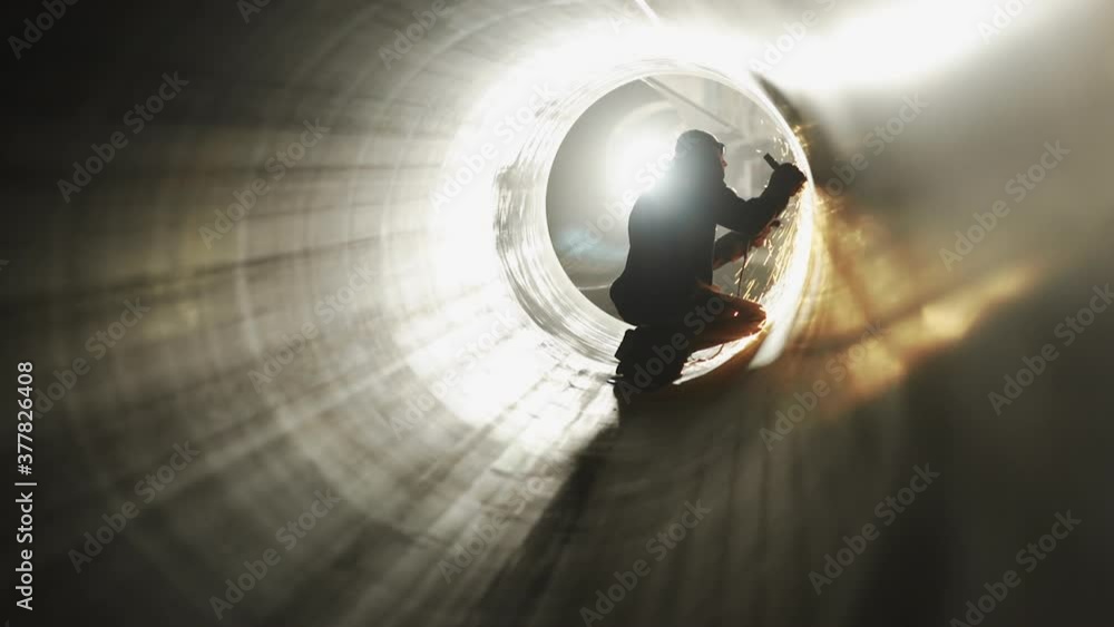 Professional Heavy Industry worker Working Inside Pipe, Wears glasses ...