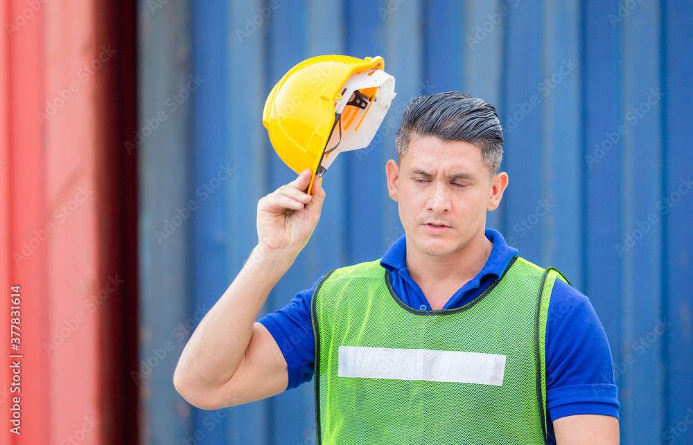 Factory worker taking off yellow safety helmet at cargo container Stock ...