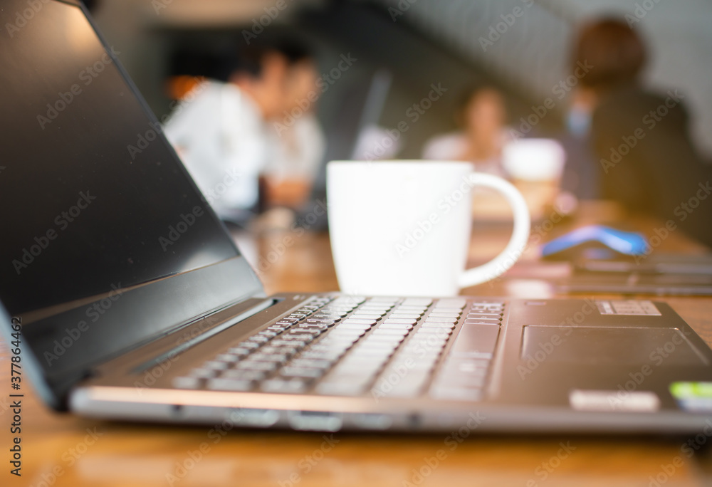 Blurry pictures of notebook computers on tables and people sitting in ...