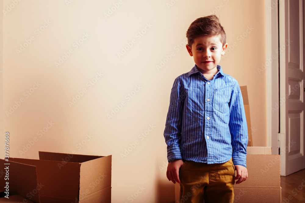 little cute boy in empty room, move to new house. home alone among ...