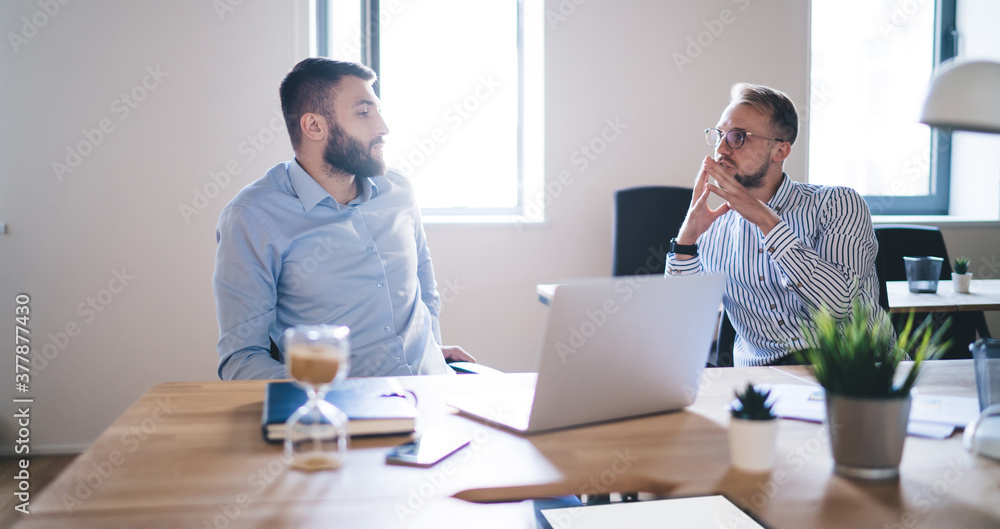 Skilled Caucasian colleagues in smart casual clothing collaborating at ...