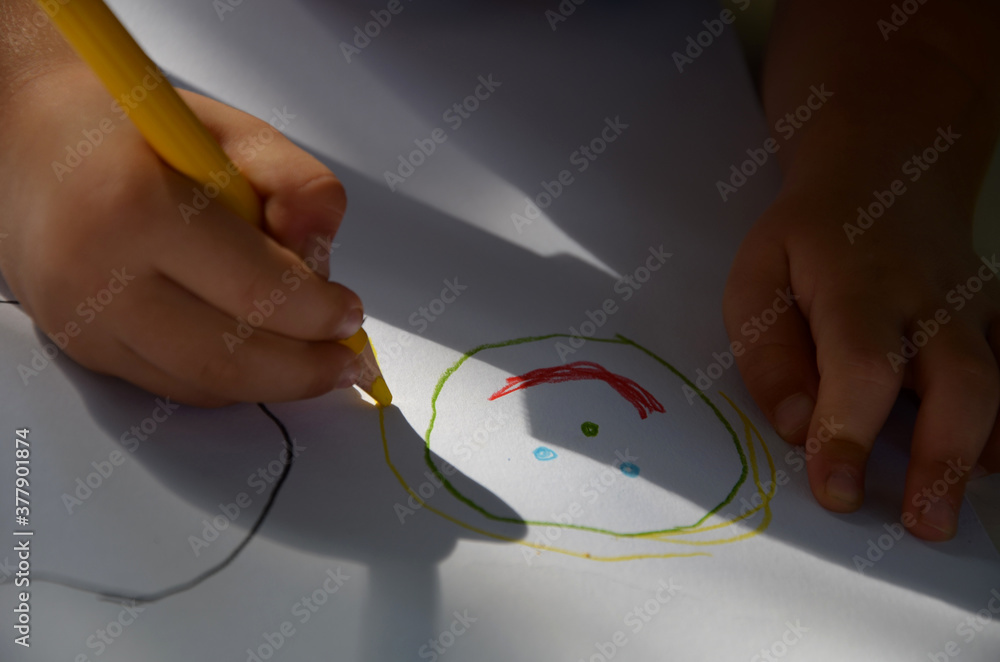 little children draw with colored crayons at a white table in the ...