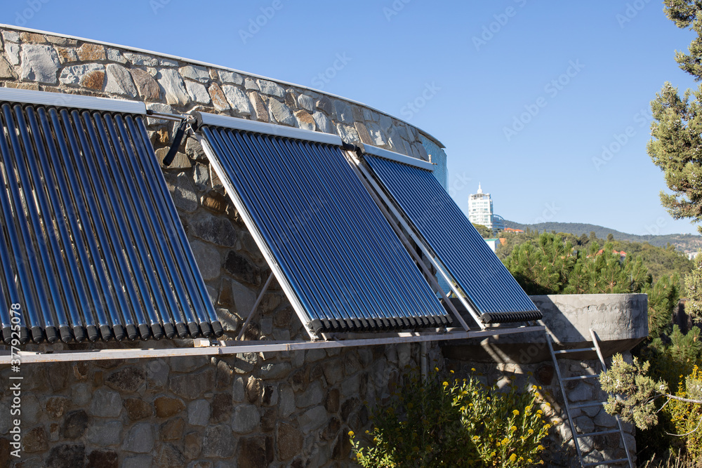Solar water heating system installed on wall or roof of house. 3 panels ...