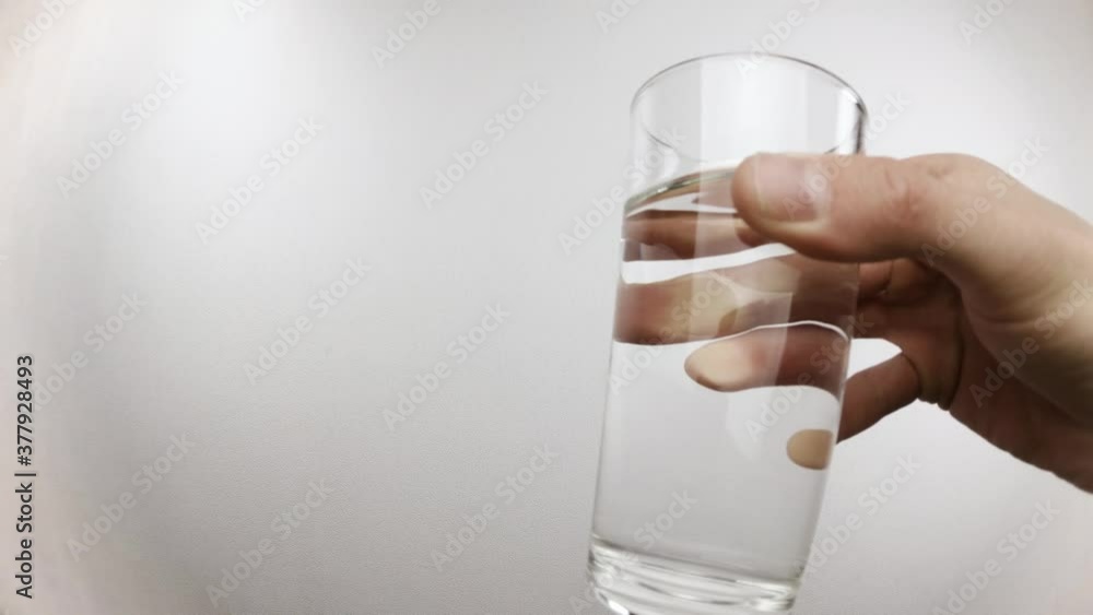 Vidéo Stock Man is holding clear glass in his hand and drinking water ...