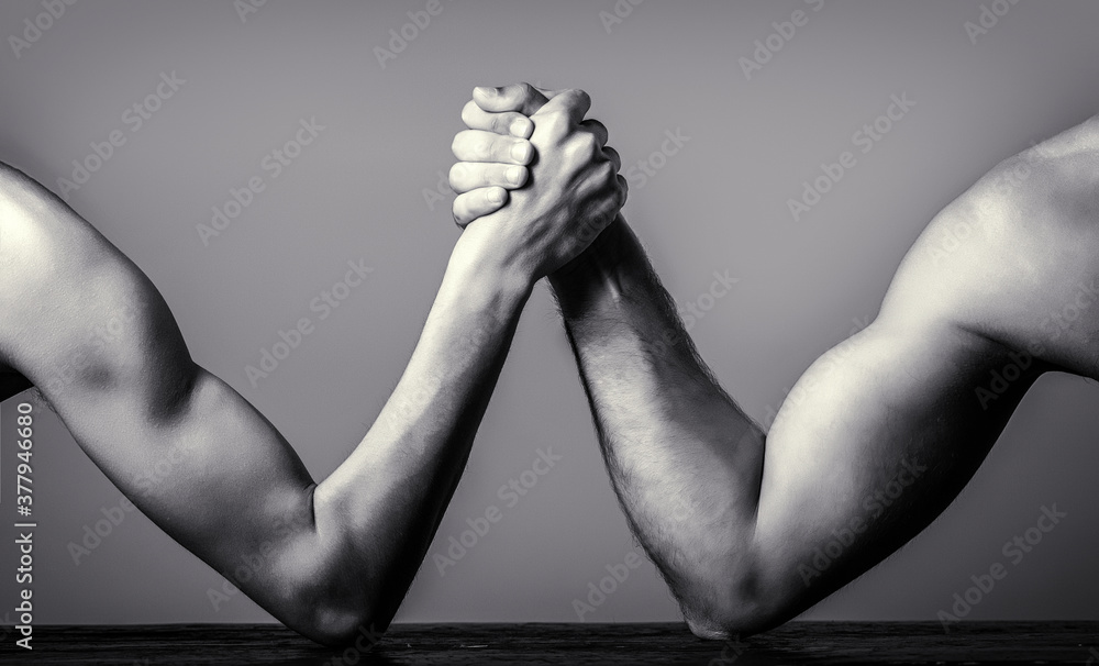 Two man's hands clasped arm wrestling, strong and weak, unequal match ...