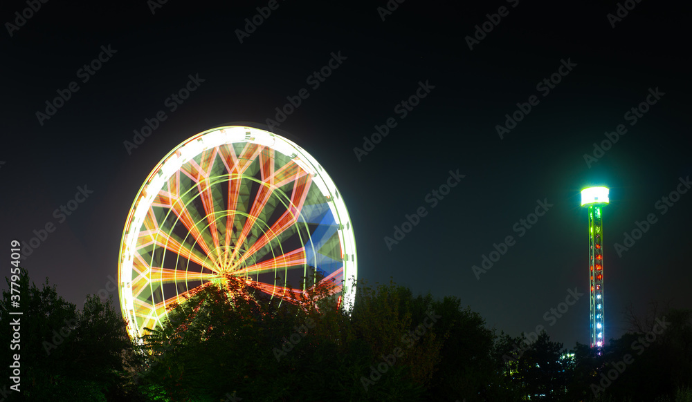 Ferris Wheel and Drop Tower at night Photos | Adobe Stock
