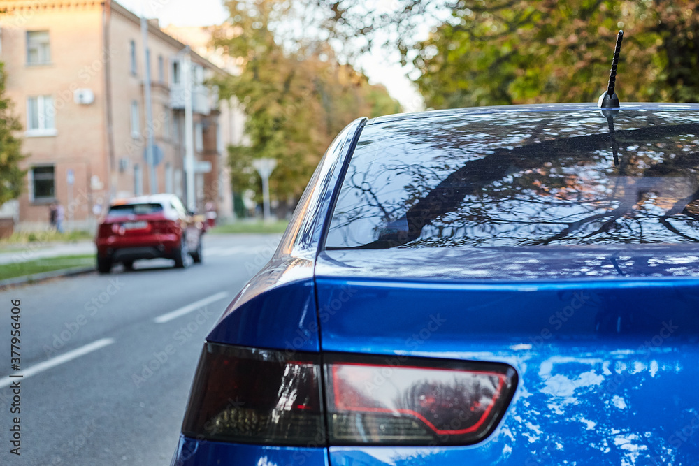 Back window of blue car parked on the street in summer sunny day, rear ...