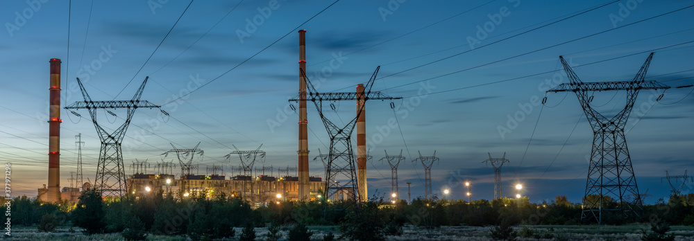High-voltage pylons running straight from the power plant against the ...