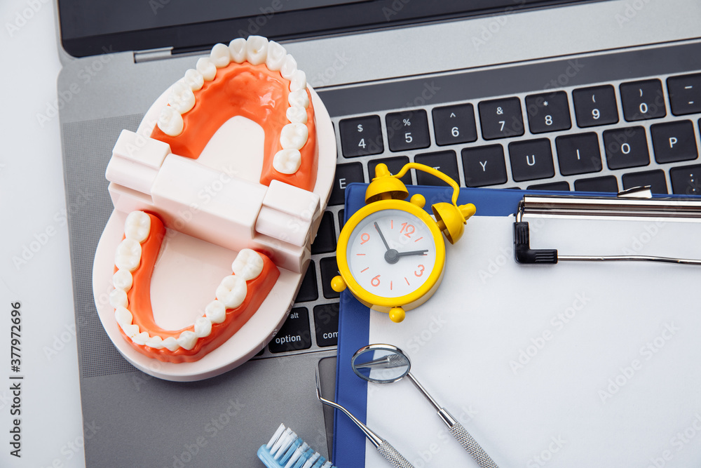 Healthy tooth model with dental tool and alarm clock in dentist's ...