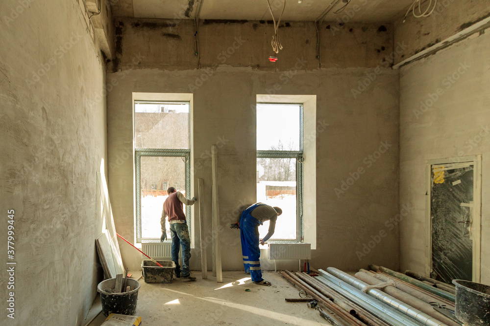 Drywall installation work in progress by construction workers at ...