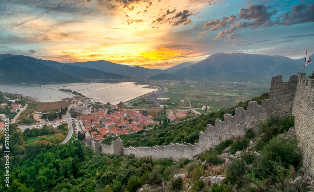 Dreamy sunset sky above Maly Ston castle and salt mines on the Adriatic ...