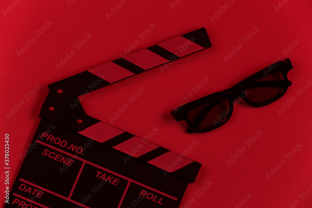 Horror movie. Film clapper board with 3D glasses in red neon light. Top ...
