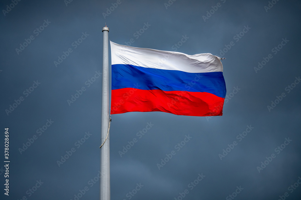 Russia flag waving on blue storm clouds sky background. Concept change ...