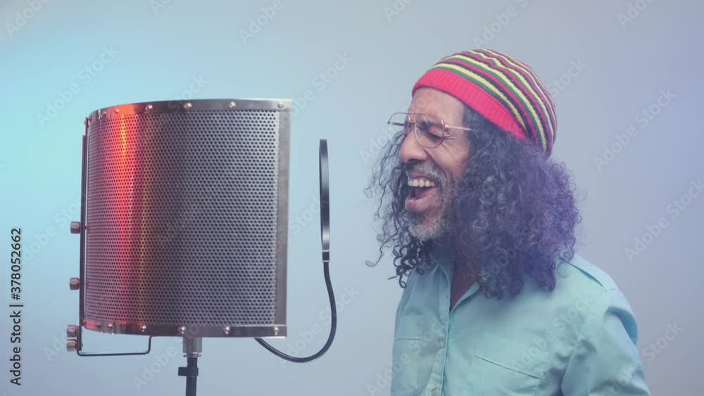 African Rastafarian singer male wearing a blue shirt and beanie ...