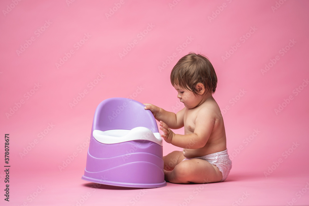 cute baby in a diaper is sitting next to a pot. Toilet and potty ...