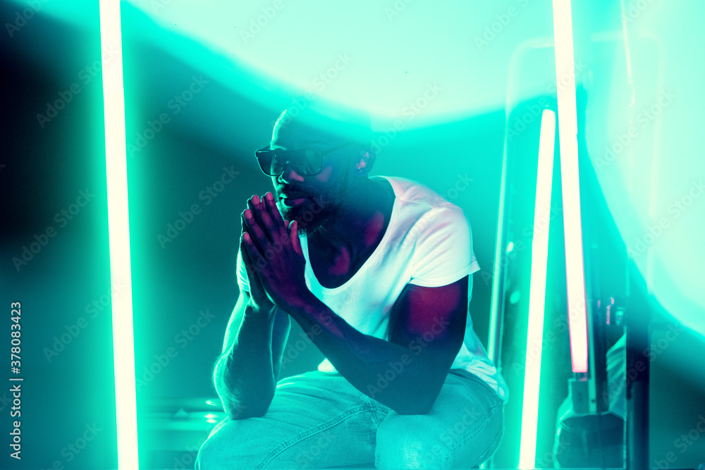 Rap star. Cinematic portrait of stylish young man in neon lighted room ...