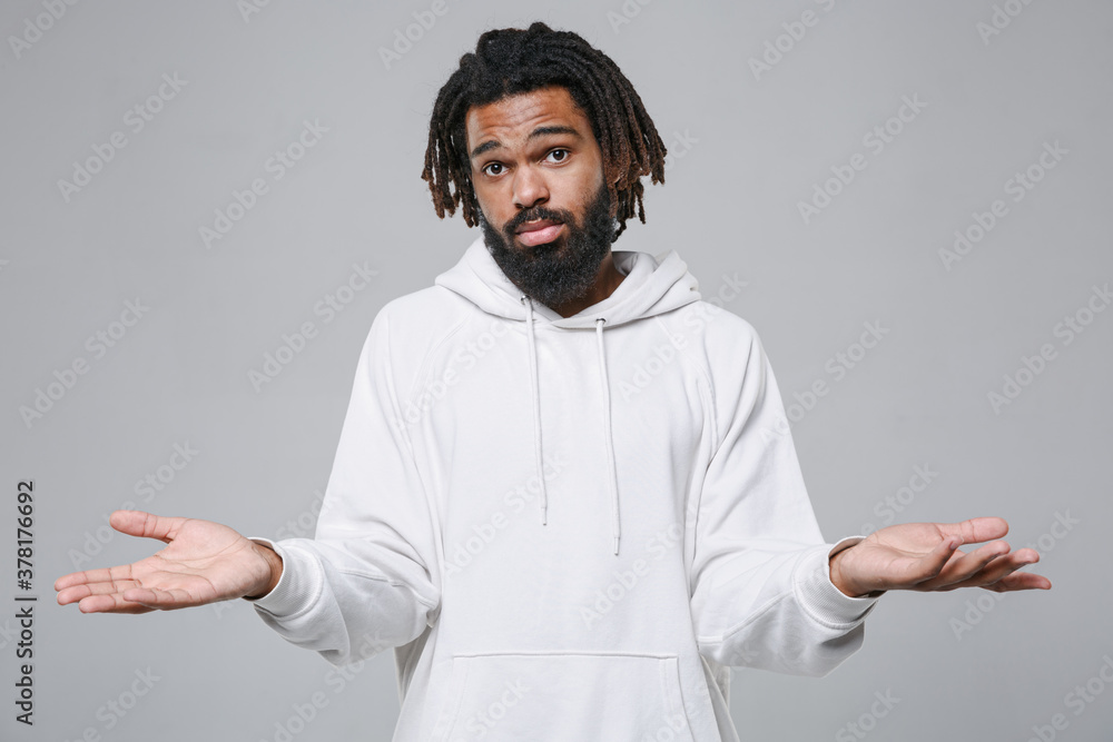 Puzzled confused young african american man with dreadlocks 20s wearing ...