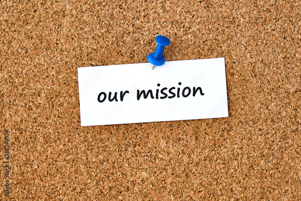 Our mission. Text written on a piece of paper, cork board background ...