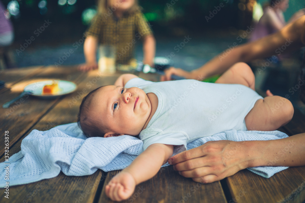 Mother laying baby on table outdoors Stock Photo | Adobe Stock