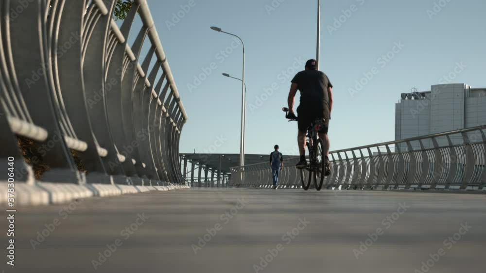 Caucasian fat man is riding bike and doing cardio exercises on ...