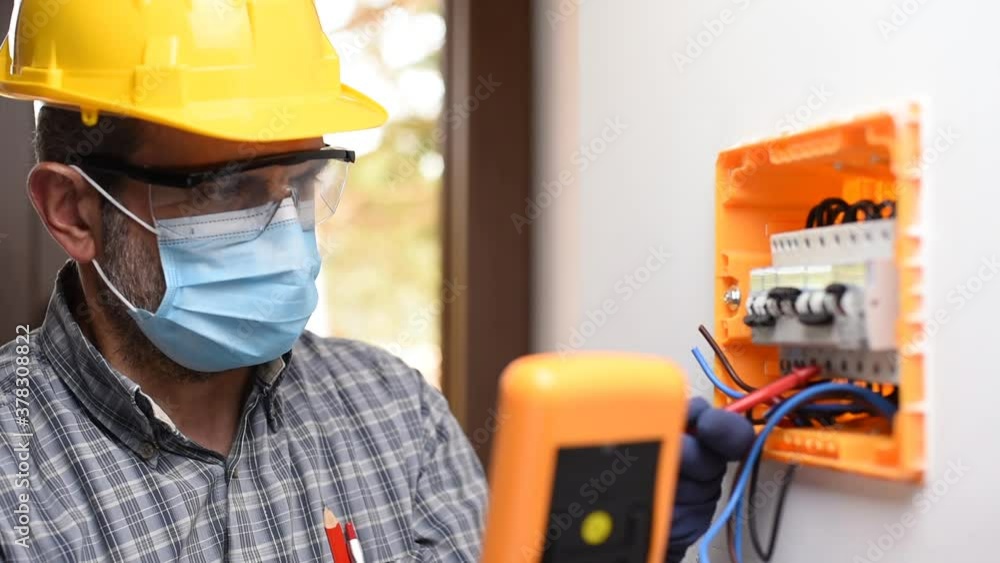 Stockvideo Electrician at work on an electrical panel protected by ...