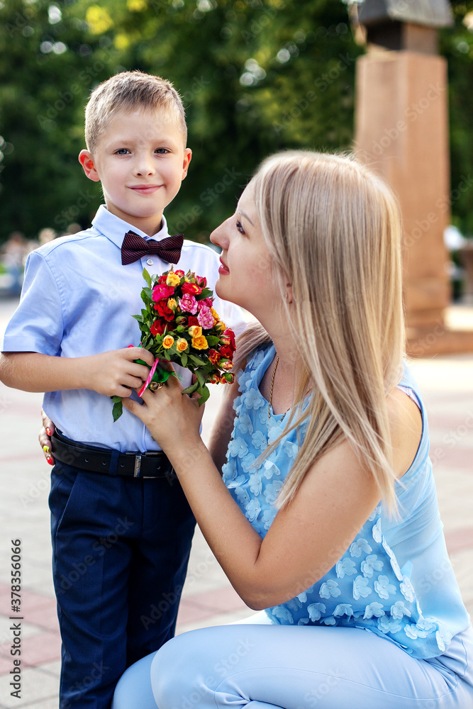 a charming 6-year-old blond boy in a light shirt and bow tie with a ...