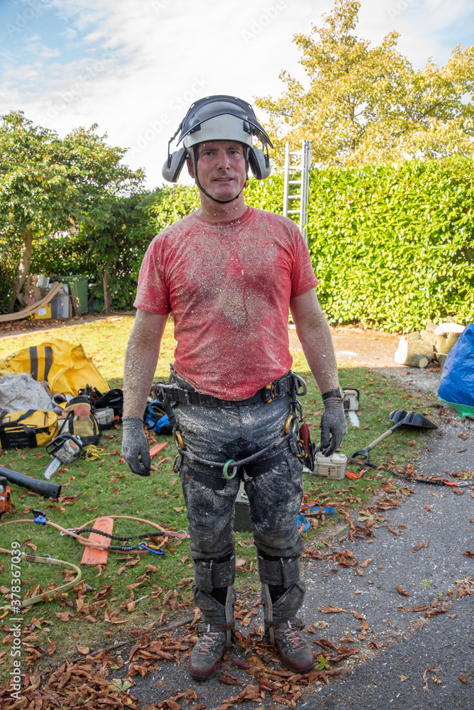 Arborist or Tree Surgeon wearing safety equipment covered in sawdust ...