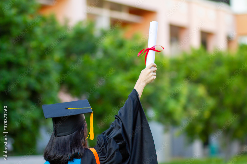 Graduates raise their hands to celebrate graduation with diplomas and ...