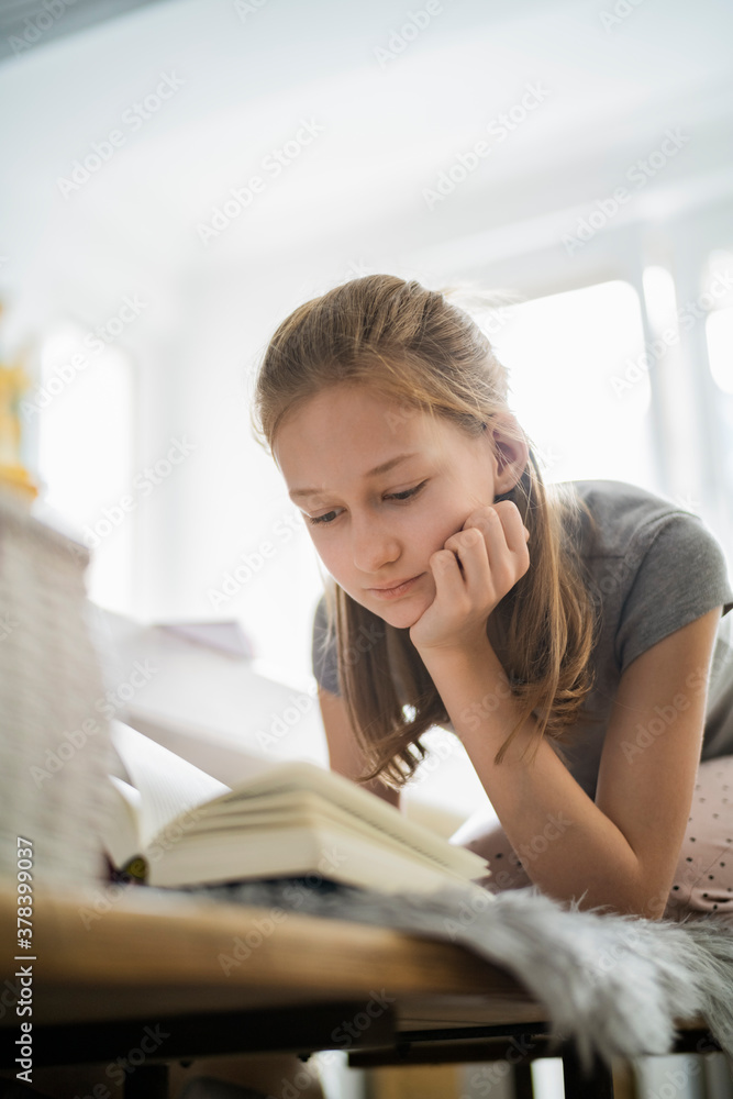 Girl reading a book at home Stock Photo | Adobe Stock